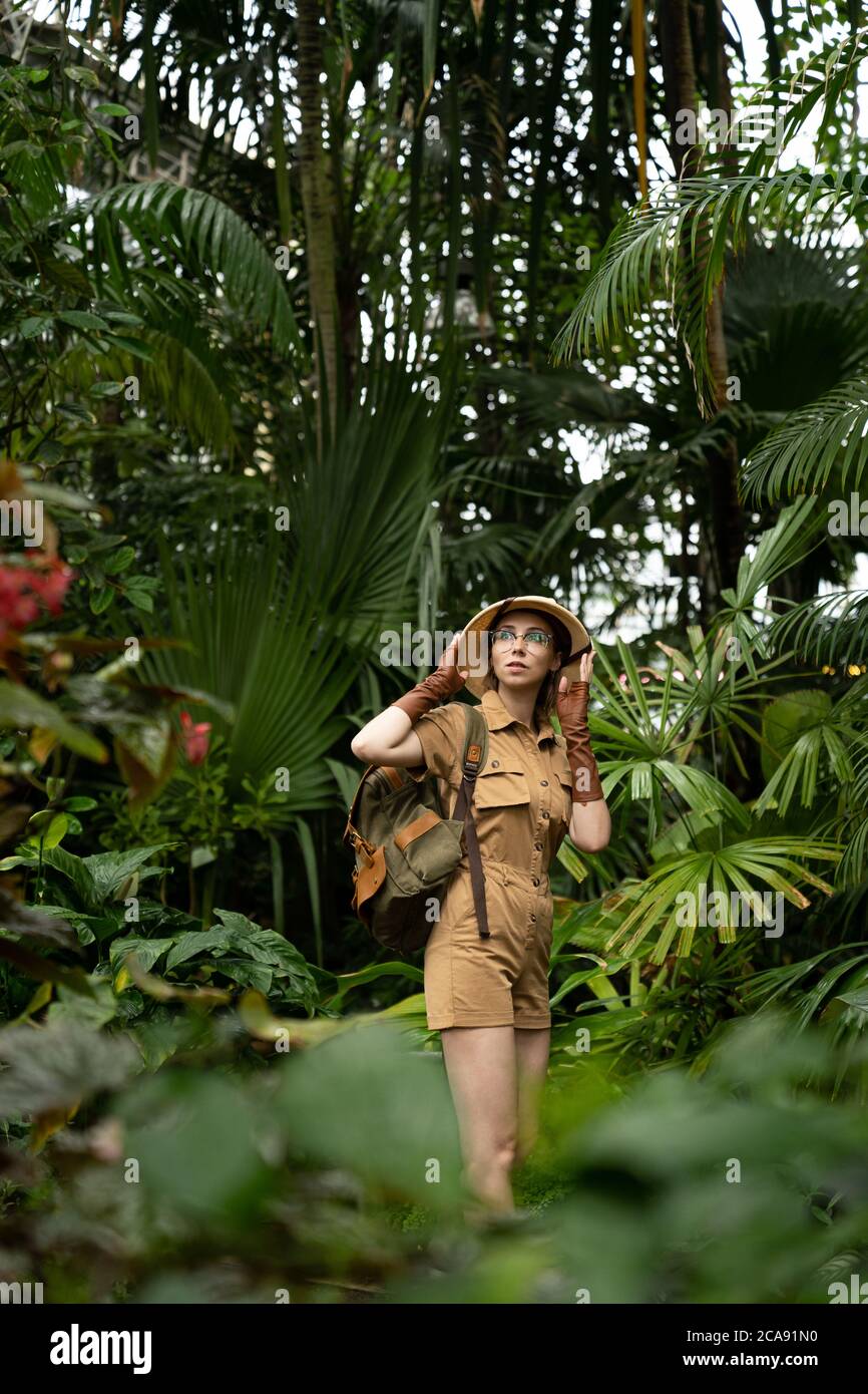 Woman botanist dressed in safari style in greenhouse. Naturalist in ...