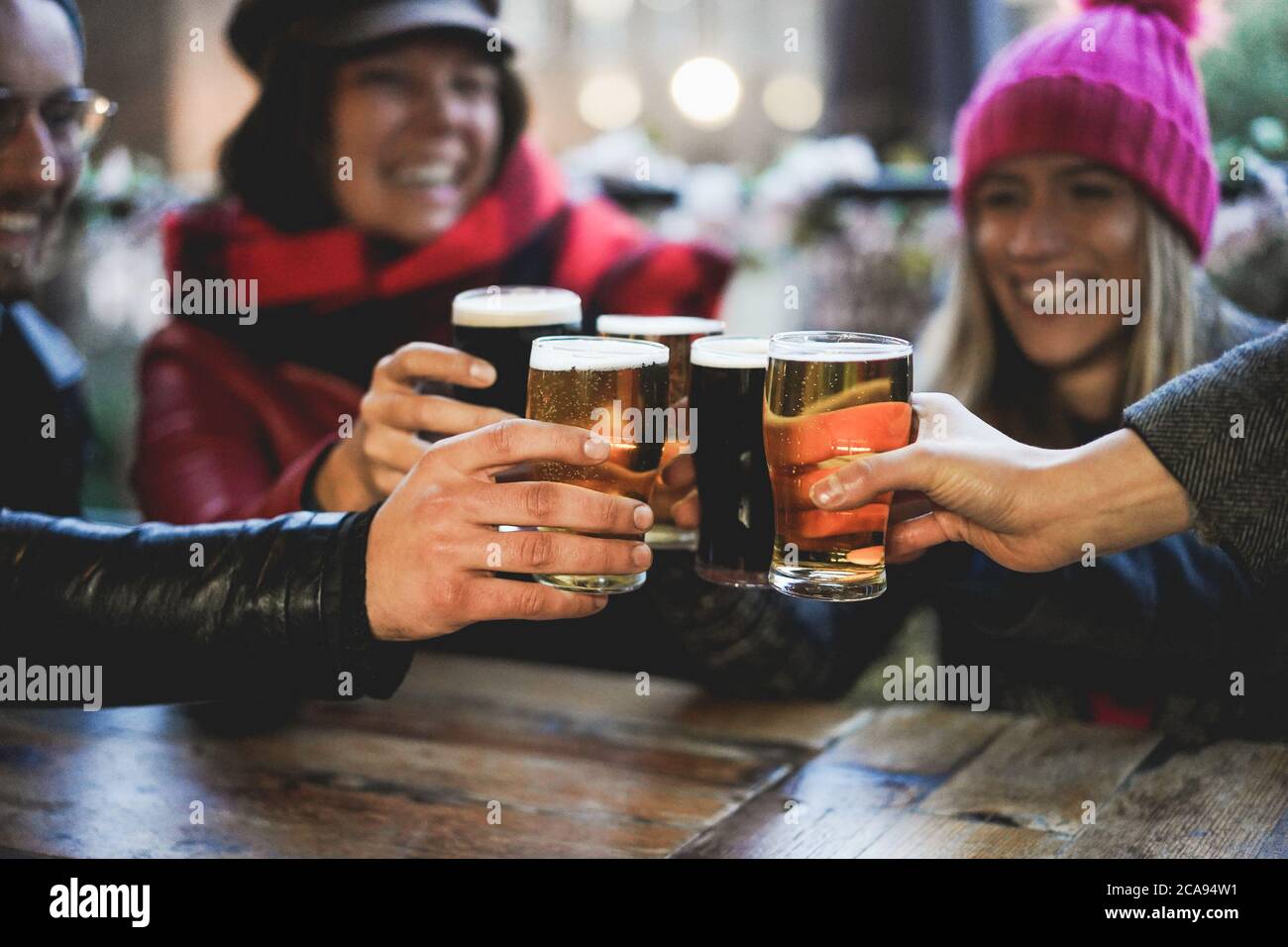 Group of happy friends drinking and toasting beer at brewery bar ...