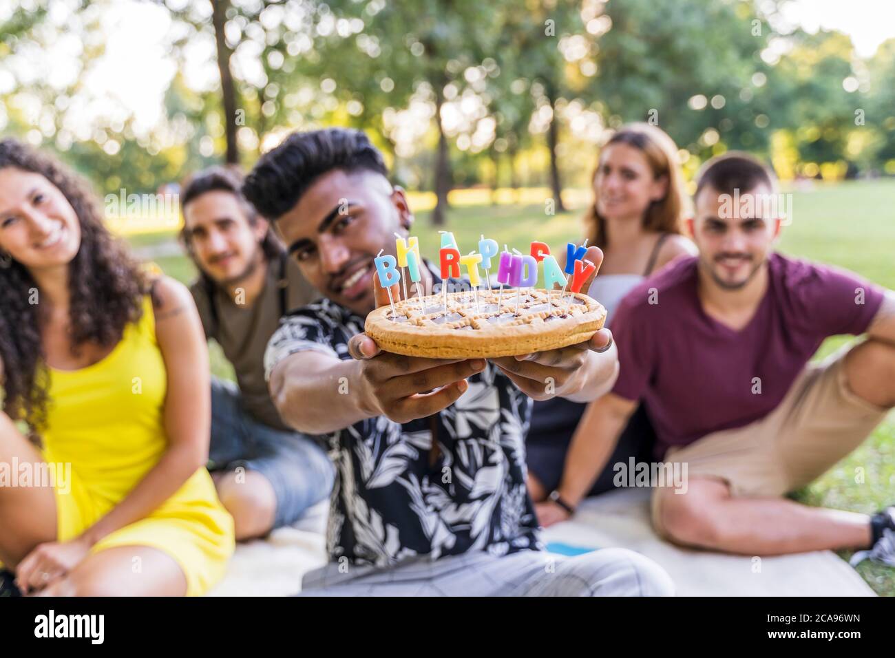multiethnic group of millennial friends celebrating a birthday with a ...