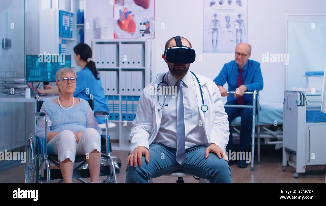 Doctor wearing VR headset, diagnosing senior woman problems while she ...