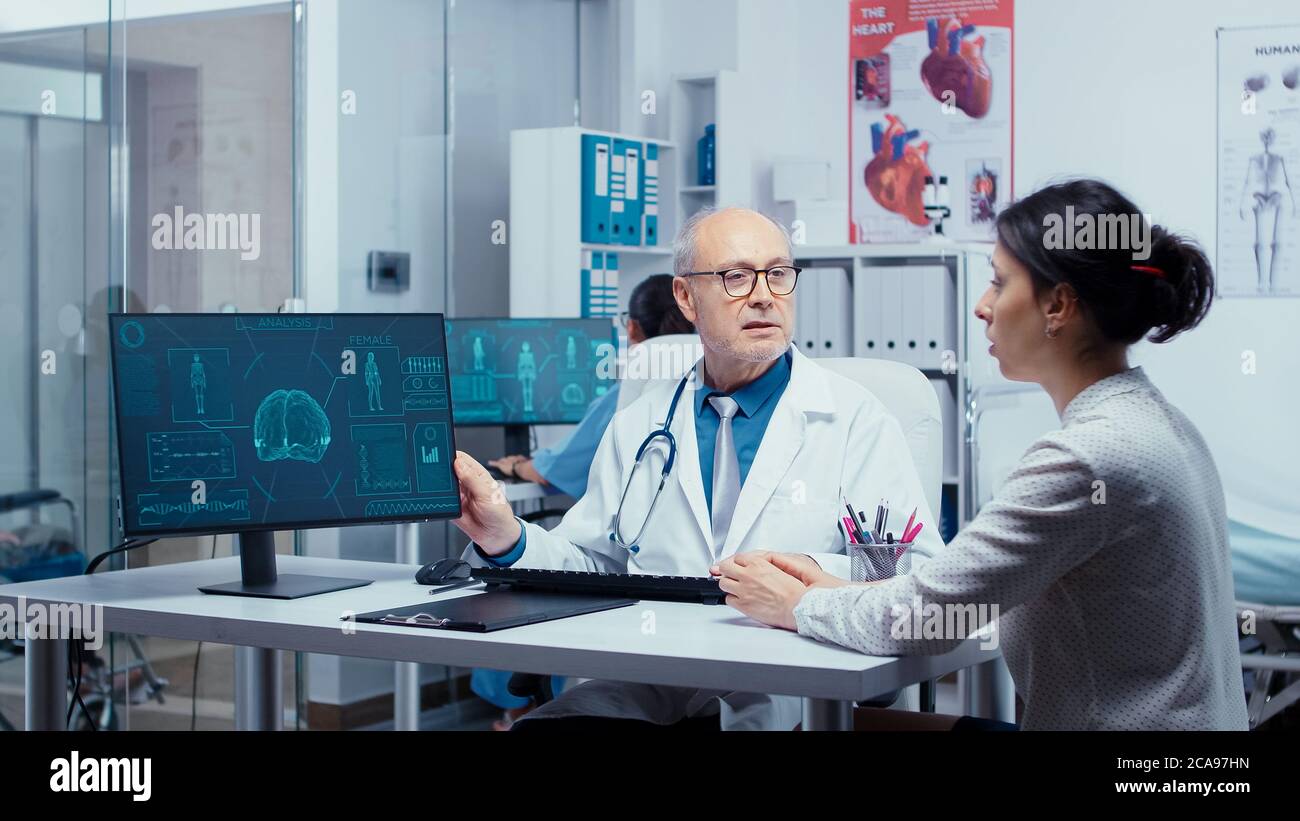 Old experienced practitioner presenting modern X Ray on computer ...