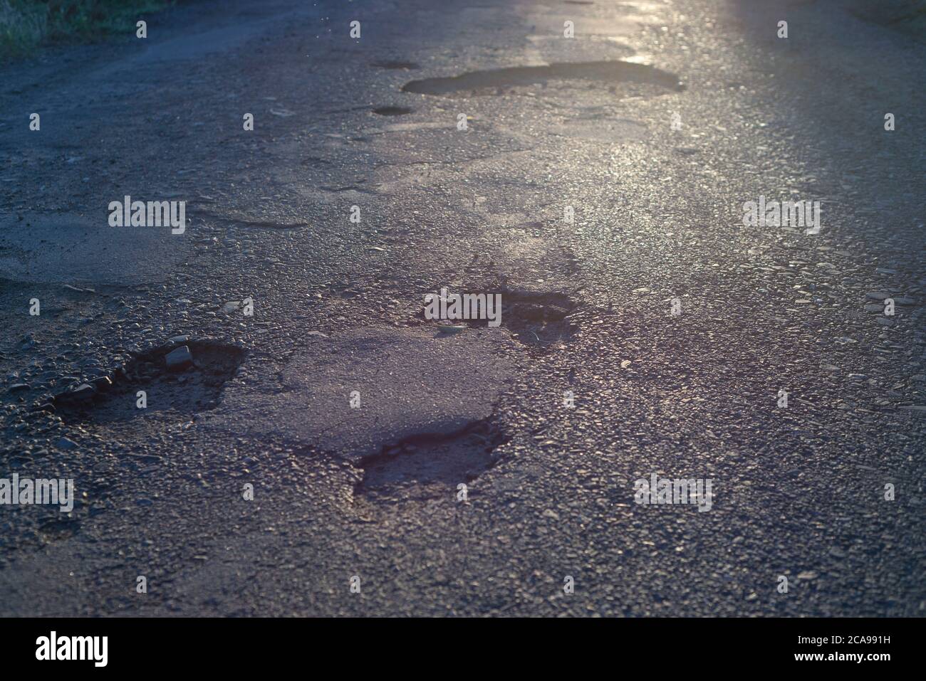 holes in the road, destroyed cracked asphalt on the road, not repaired ...