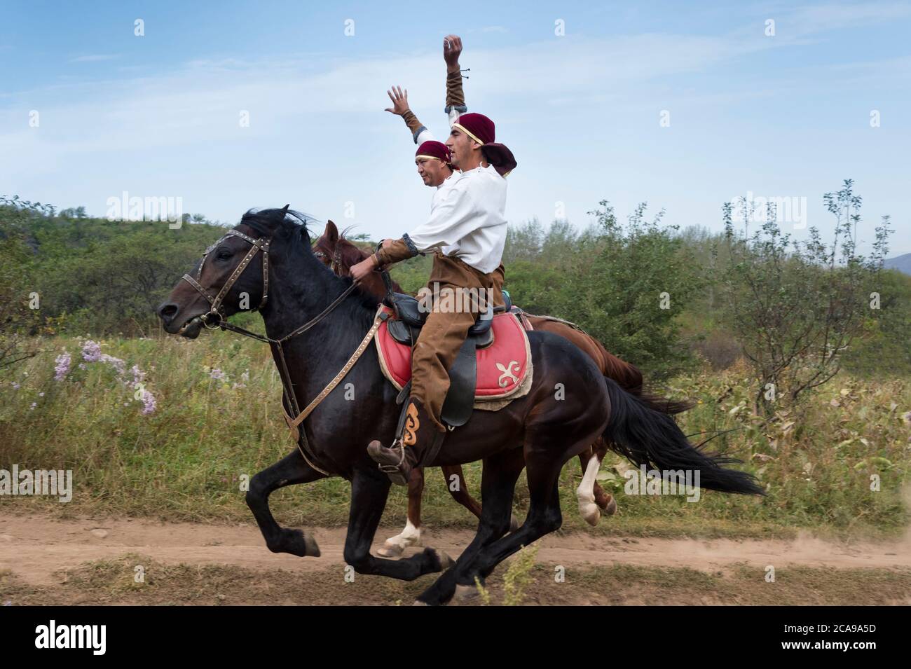 Two riders galloping, Kazakh ethnographical village Aul Gunny, Talgar ...