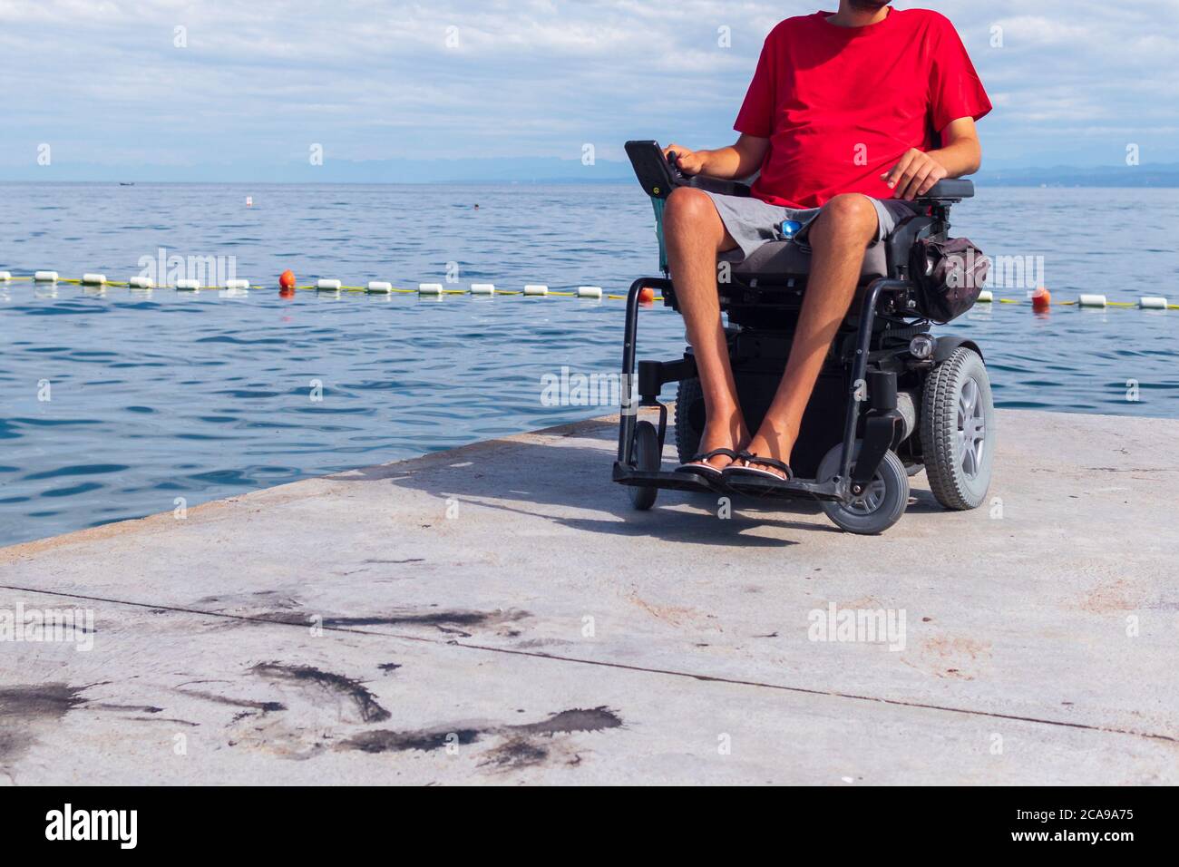 Man with handicap on the beach with a beach wheelchair hi-res stock ...