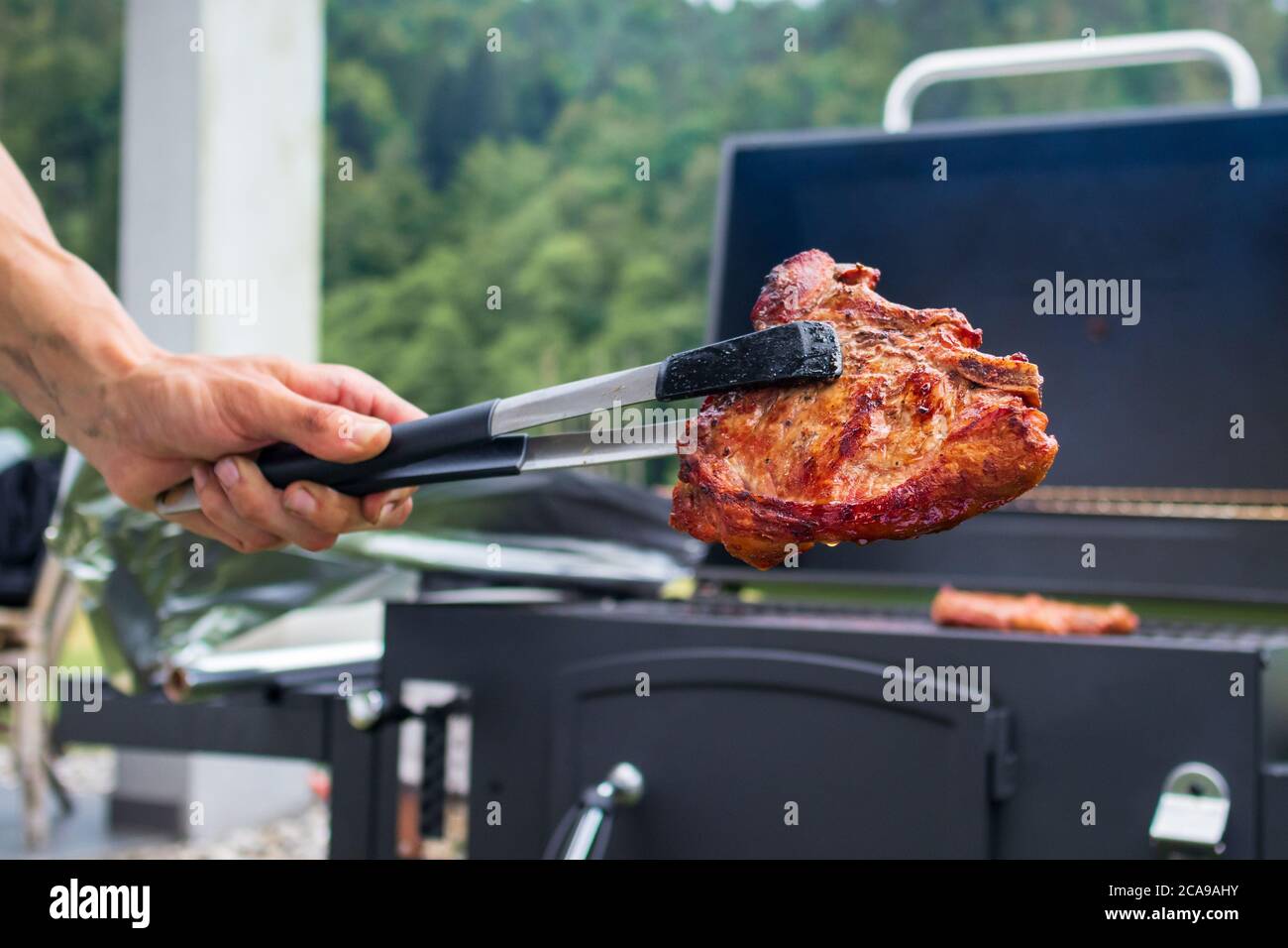 Home barbecue with charcoal in the backyard grilling steaks and other ...