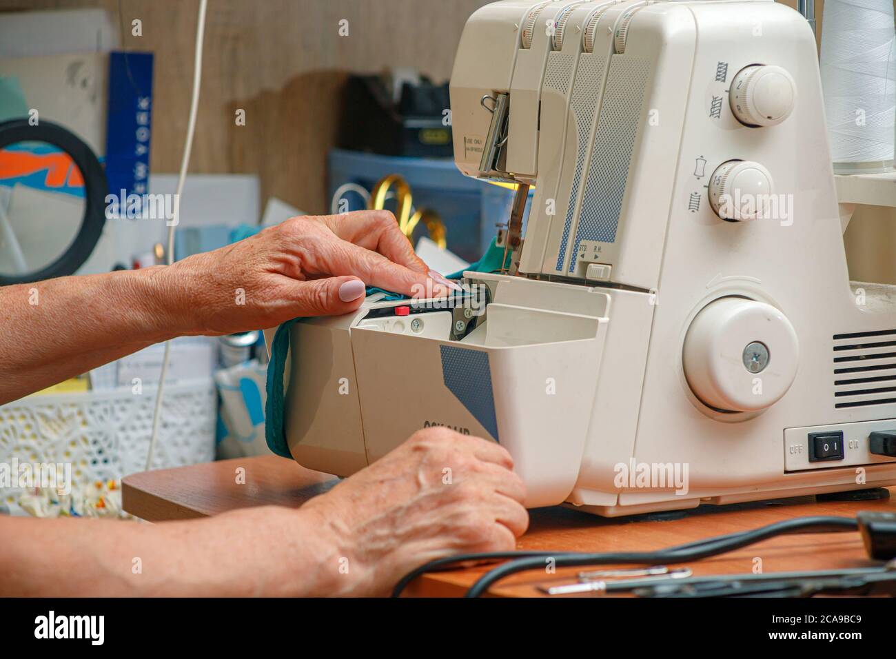 female old wrinkled hands sew on a sewing machine Stock Photo - Alamy