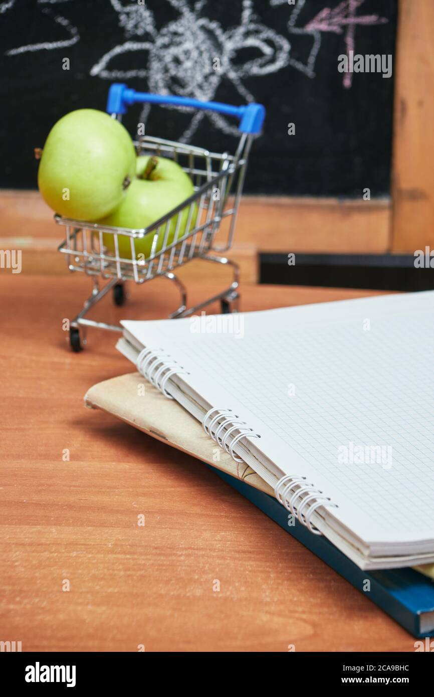 Notebooks, books on the table on the chalkboard background, school ...