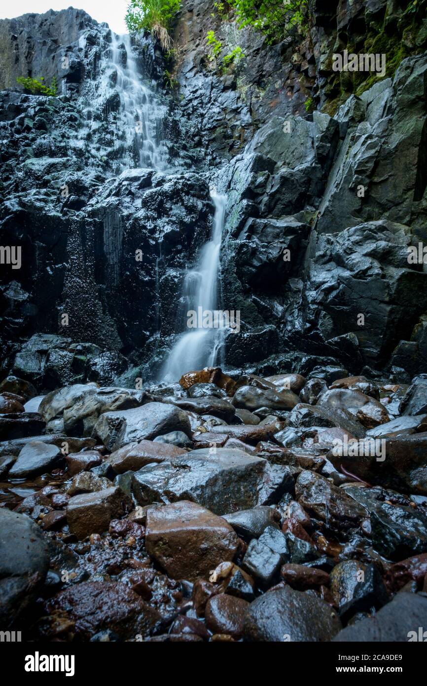 Small summer waterfall shot with slow shutter to create smooth misty ...