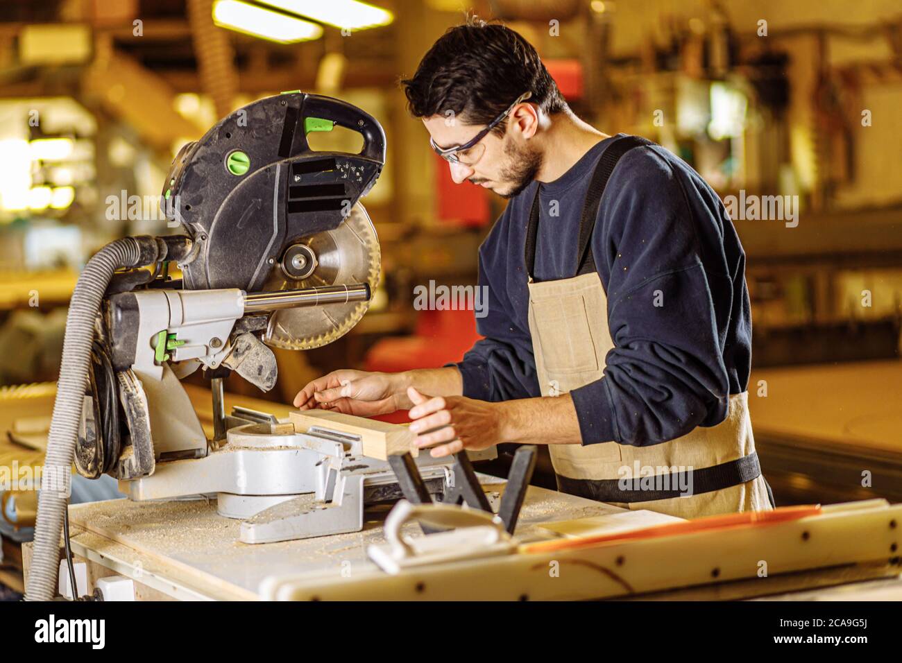 young caucasian carpenter man at work, handsome guy in work clothes use ...
