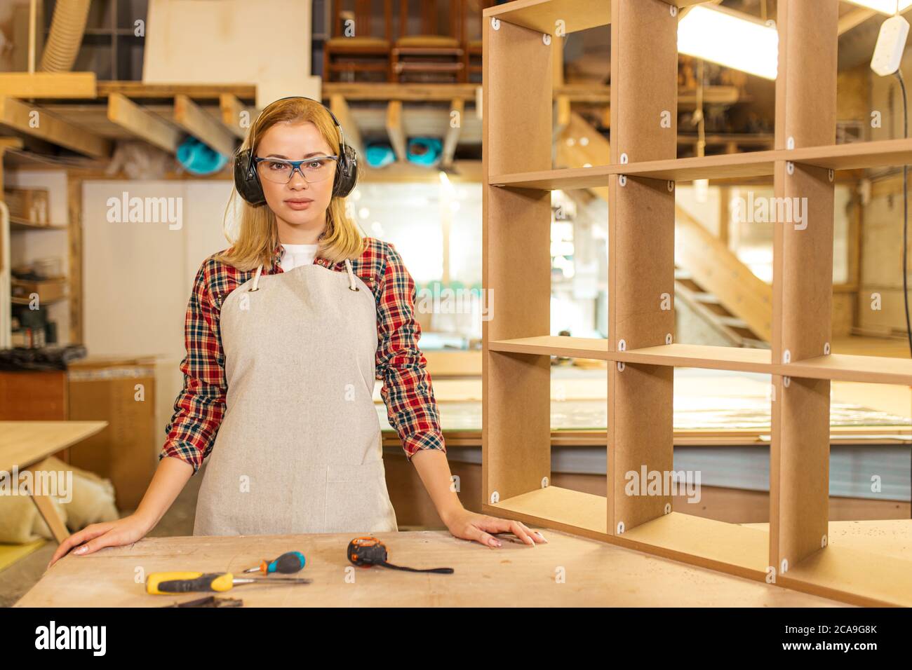 portrait of young confident woman woodworker looking at camera, female ...