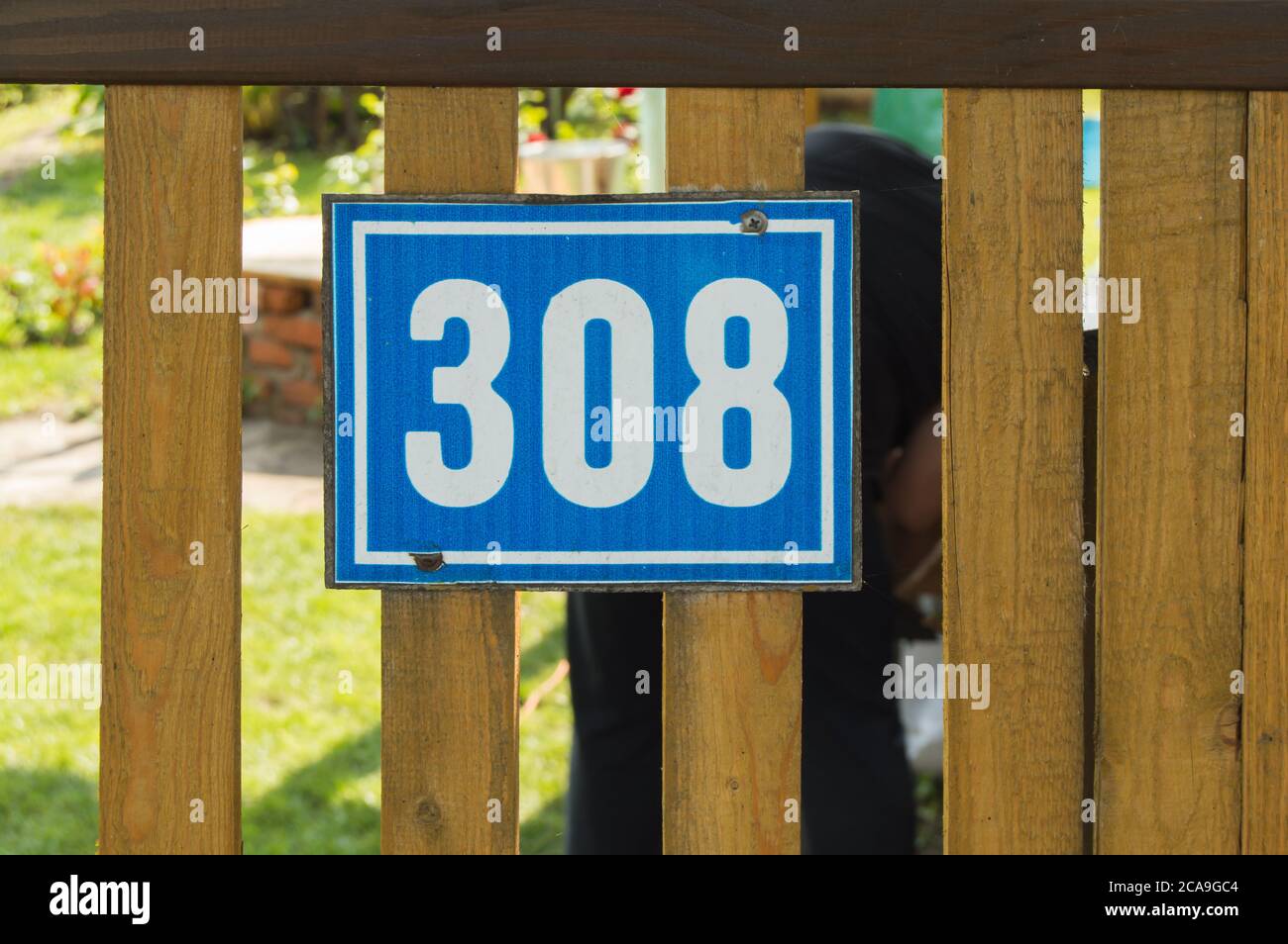 Sign with numbers of the house number, new wooden fence in a country ...
