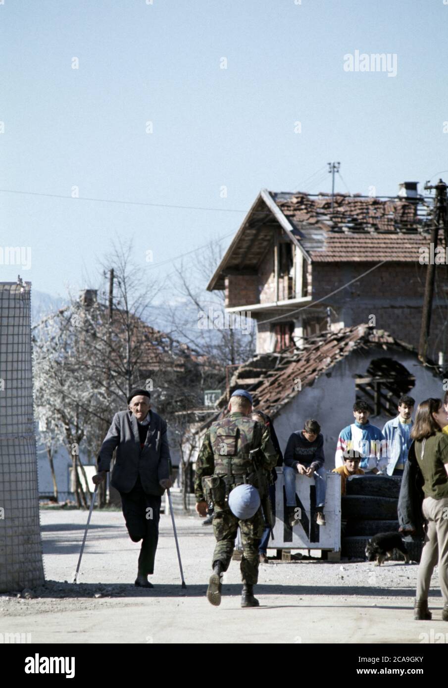 29th March 1994 During the war in Bosnia: an old man on crutches passes ...