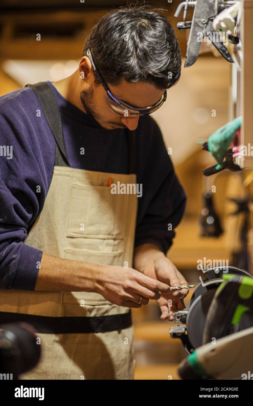 young caucasian carpenter man at work, handsome guy in work clothes use ...