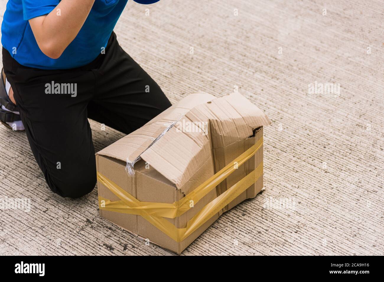 Asian young delivery man in blue uniform he emotional falling courier ...