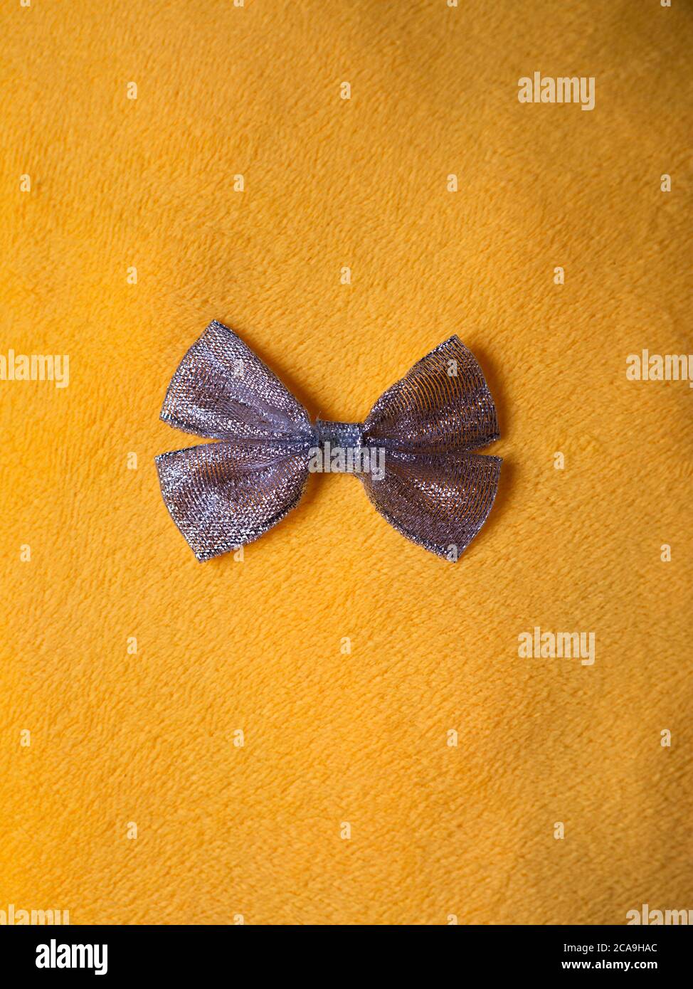 Bow on yellow surface Stock Photo - Alamy