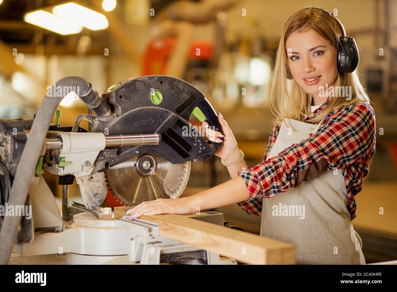 portrait of young and confident woman woodworker, lady in uniform make ...