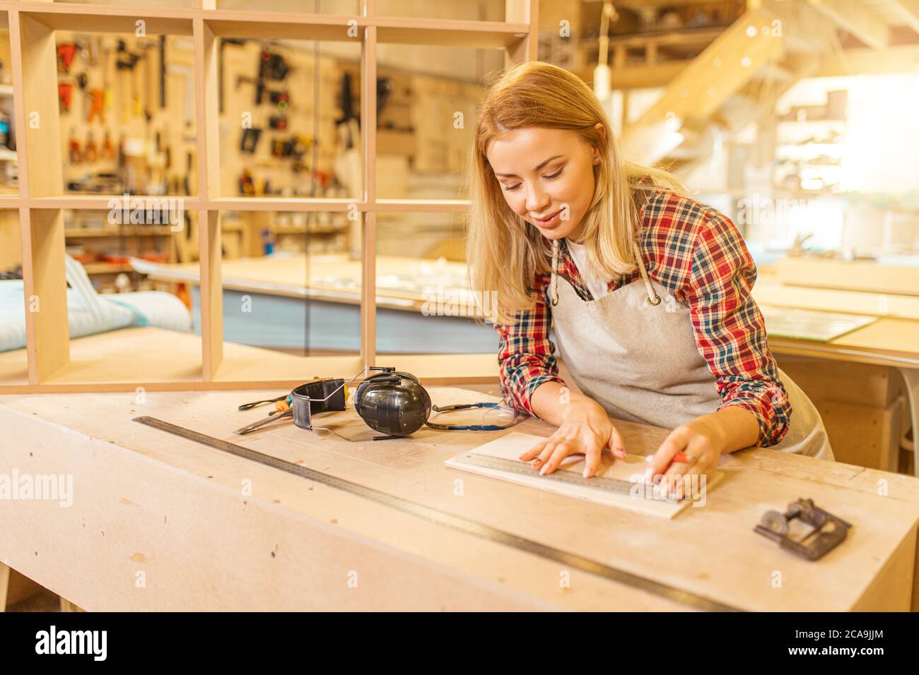 attractive caucasian carpenter lady deals with drawings during work ...