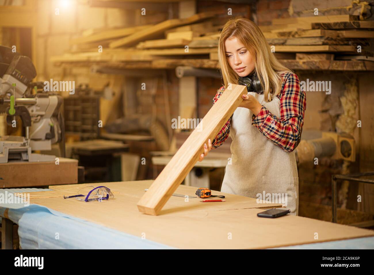 portrait of beautiful caucasian woman carpenter dealing with handicraft ...