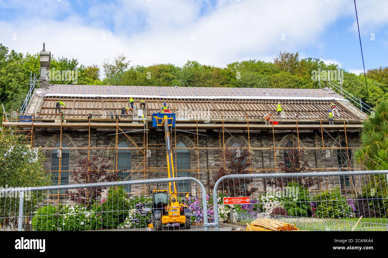 Builders working on church roof wearing PPE Stock Photo - Alamy