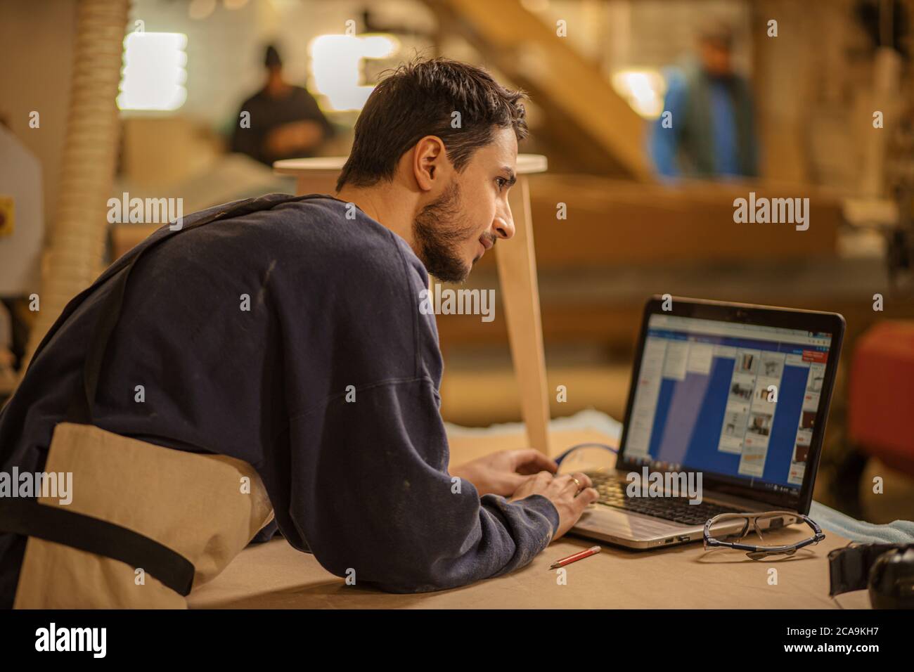 confident woodworker watching the project of making wooden chair on ...
