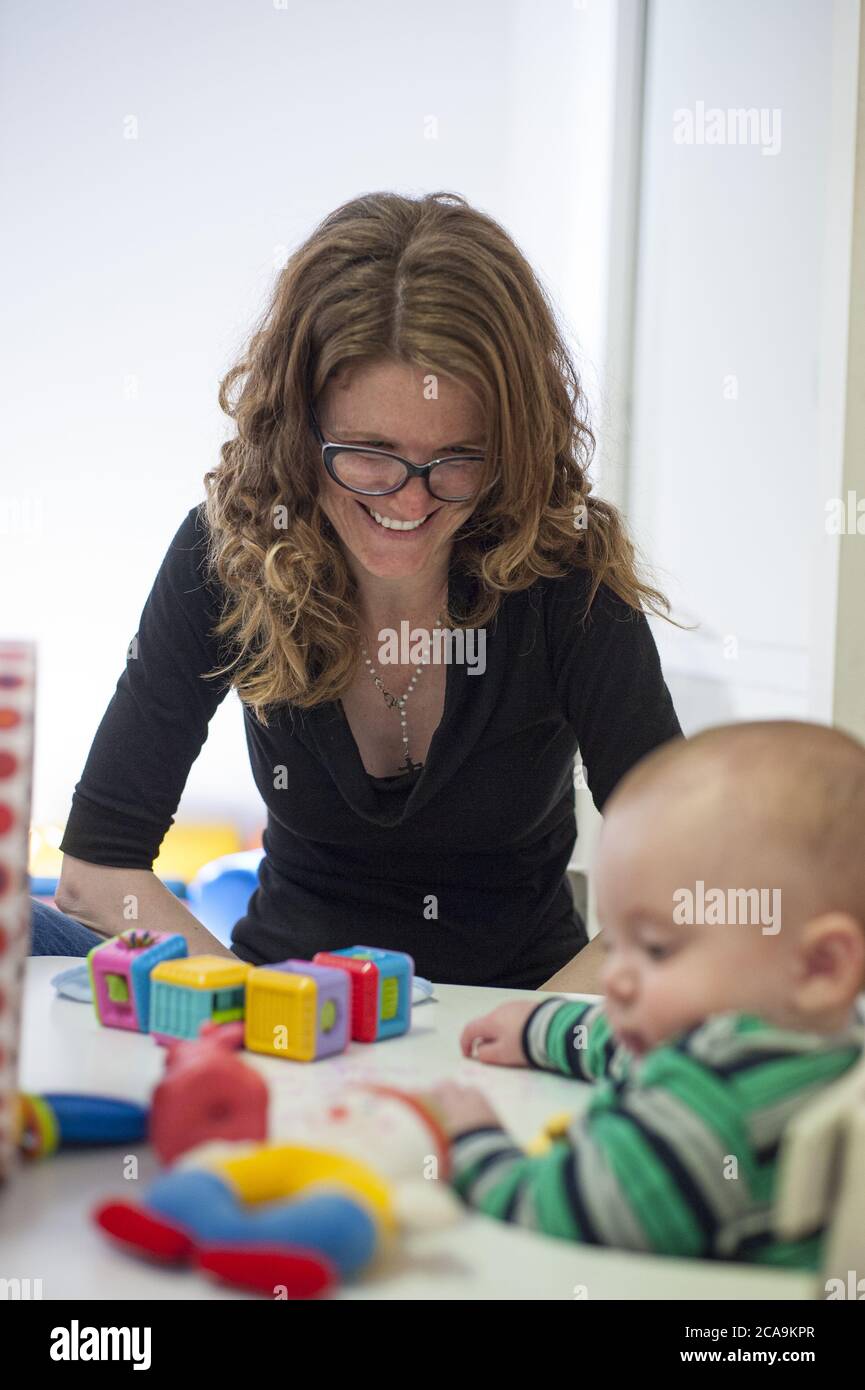 Mother smiles at her premature baby during an early stimulation session ...