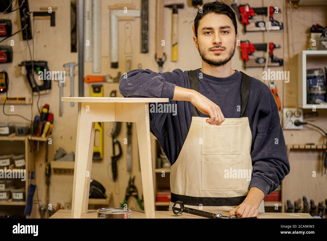portrait of young caucasian confident woodworker looking at camera ...