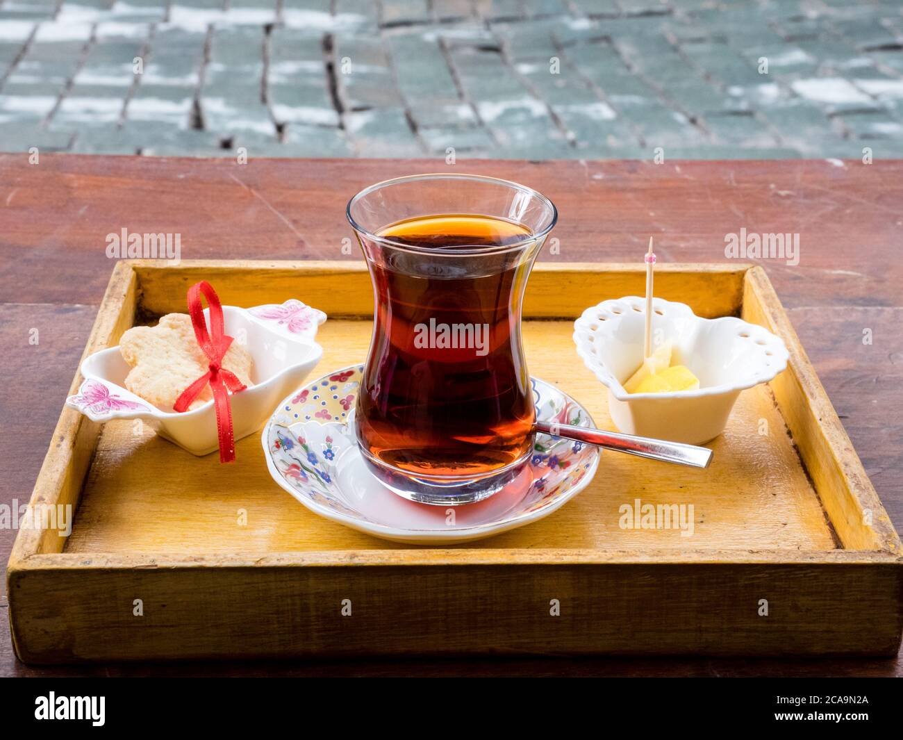 Hot Turkish tea in traditional glass on the wooden table on the street ...