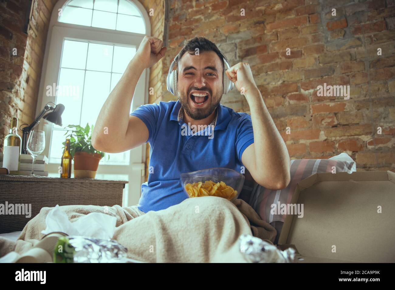 Crazy happy of favourite team. Videocall, social media. Lazy man living ...