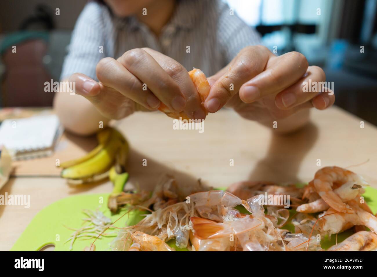 A woman peeling the steamed shrimp by hand Stock Photo - Alamy