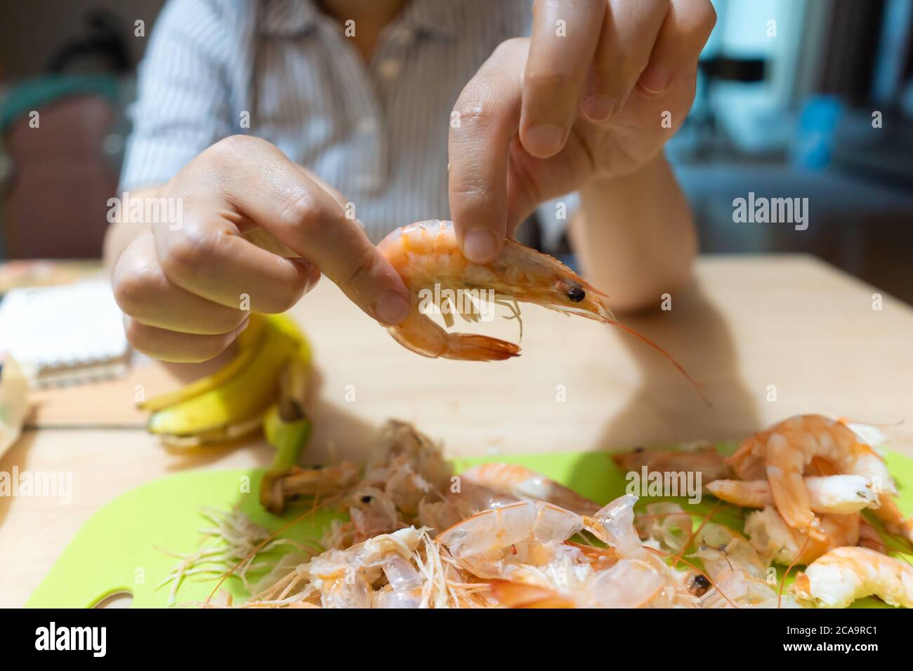 A woman peeling the steamed shrimp by hand Stock Photo - Alamy