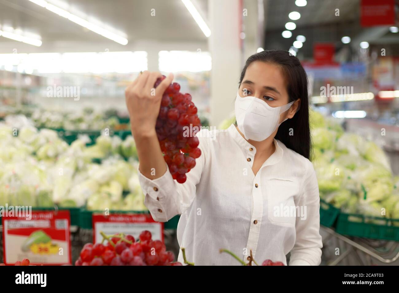 Asian woman long hair wearing protective face mask in supermarket ...