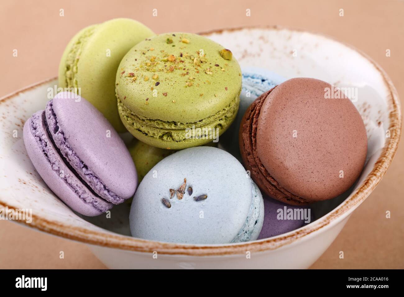 Close up several French macaroon cookies served in rustic porcelain ...