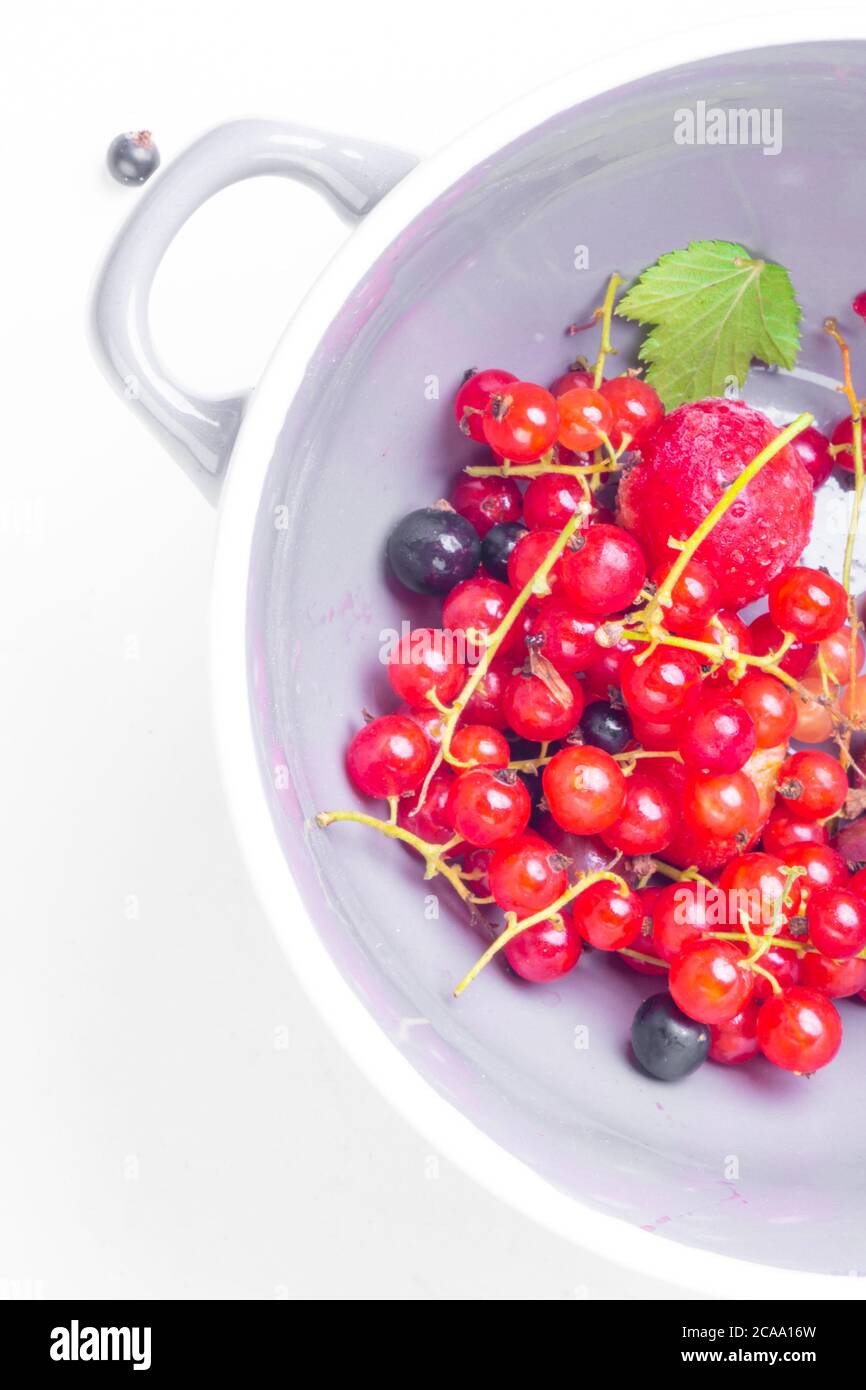 mixed fresh different berries in a bowl consisting of raw strawberries ...