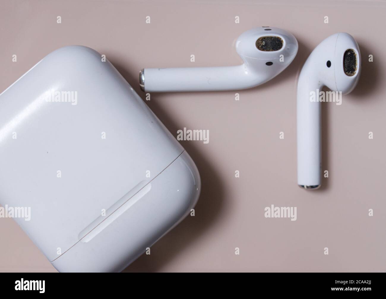 dirty bluetooth headphone on a golden pink background with case Stock ...