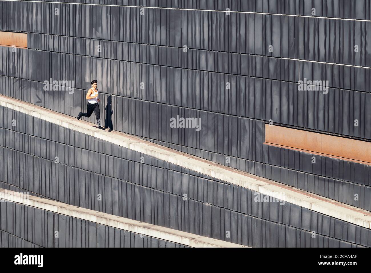 sporty man running in a concrete jungle, urban sport concept and ...