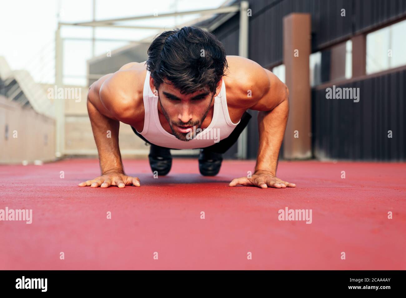 handsome sportsman doing push ups on a red floor, concept of urban ...