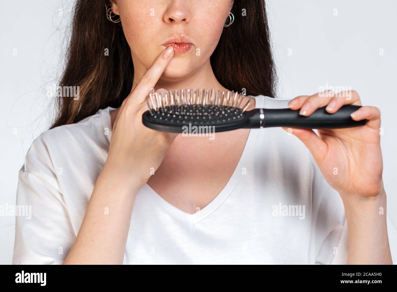 Close up portrait of a brooding brunette Woman who shows a clean comb ...