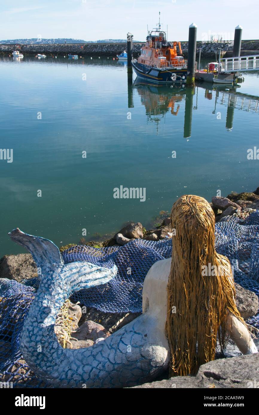 Early AM Brixham harbour views Figure of mermaid seated on boulders ...