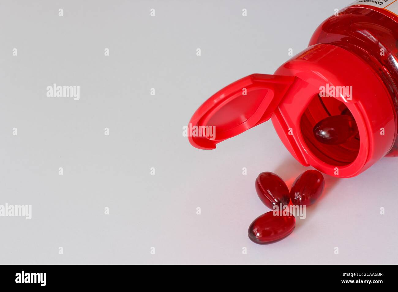 Three red tablets spilling from jar Stock Photo - Alamy