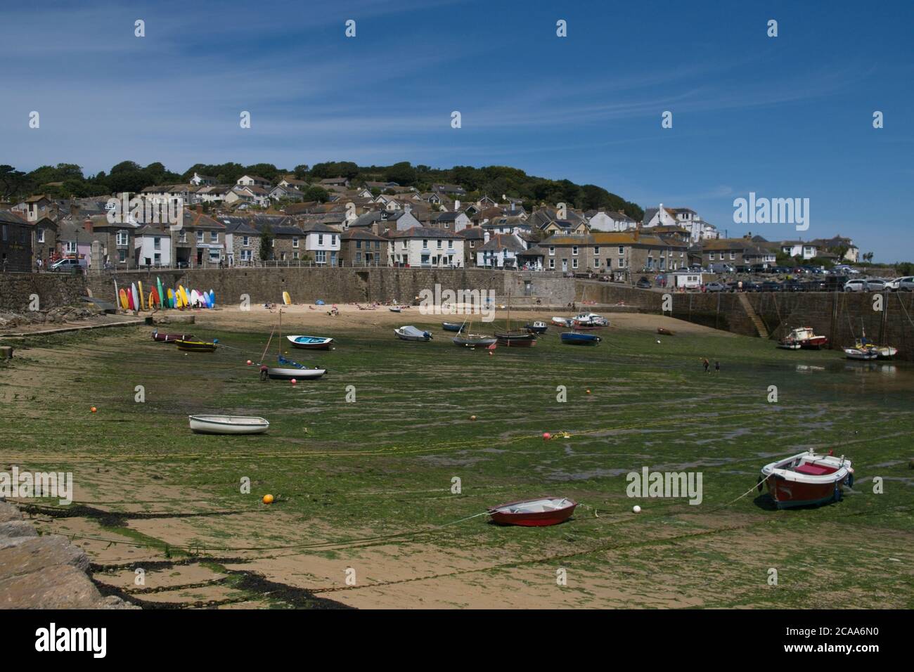 General view of Mousehole harbour low tide Dry seabed Green seaweed ...