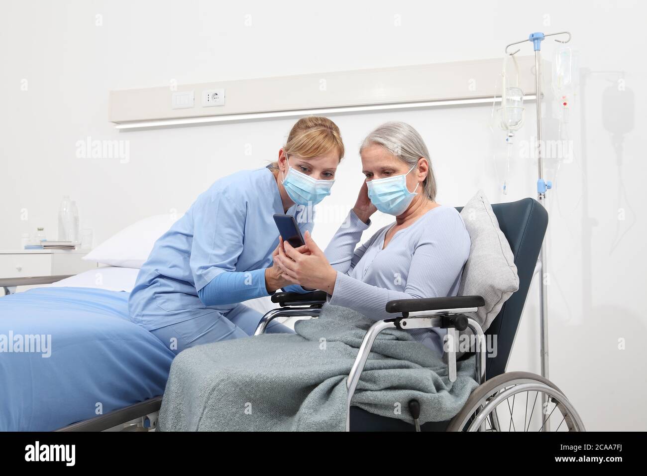 nurse helps with cell phone to contact the elderly lady's family in the ...