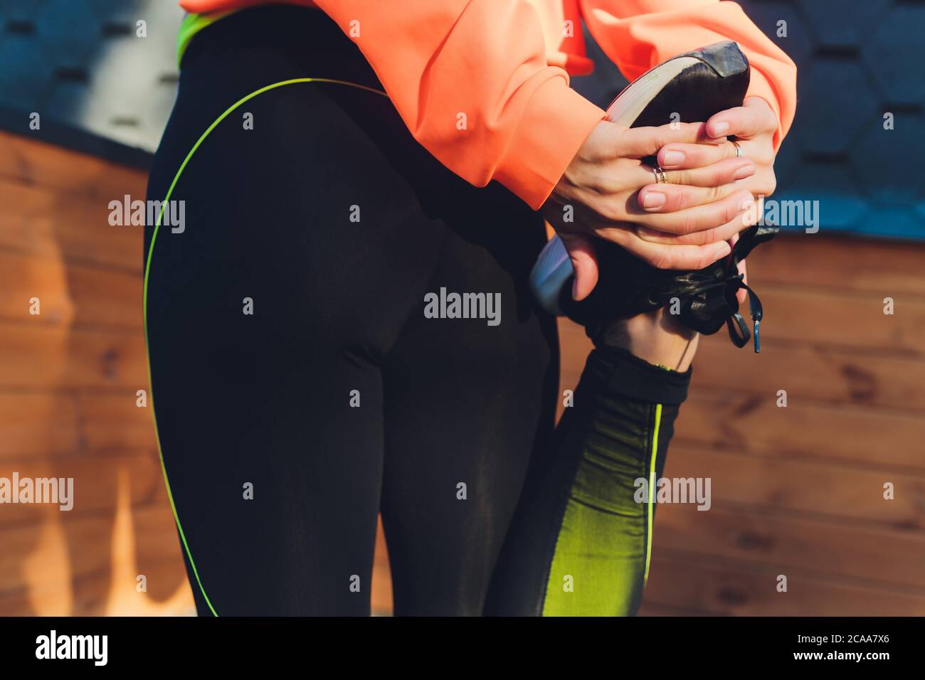 Young fitness woman runner stretching legs before run on quay, back view, empty space Stock ...