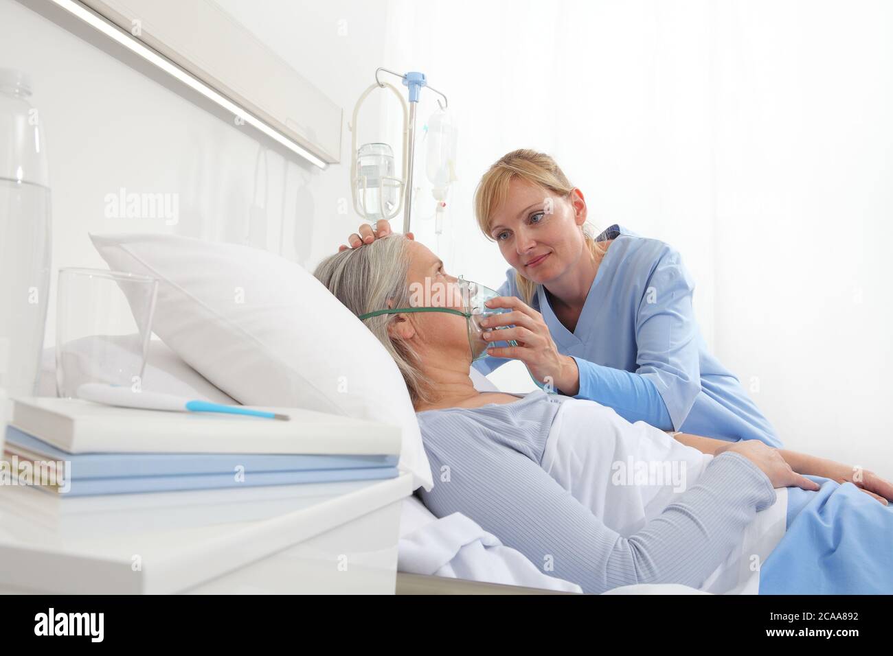Nurse Puts Oxygen Mask On Elderly Woman Patient Lying In The Hospital