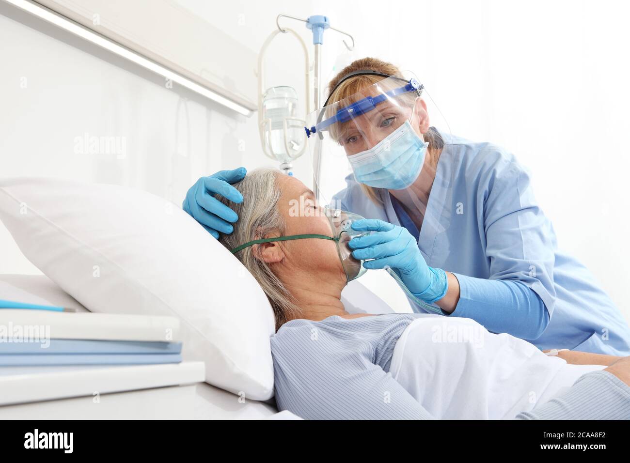 Nurse Puts Oxygen Mask On Elderly Woman Patient Lying In The Hospital