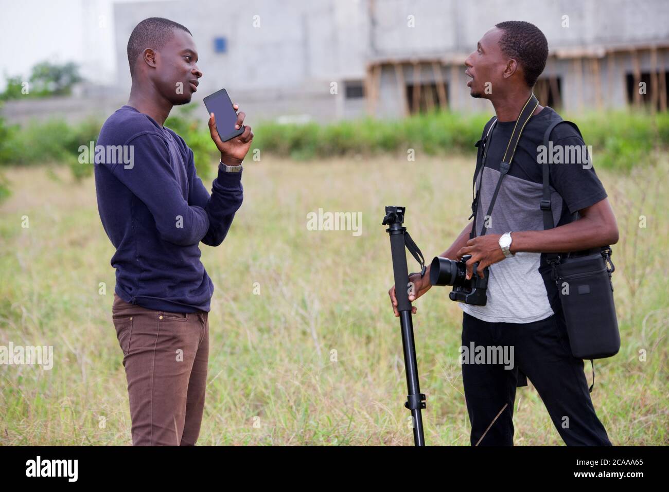 two young men photographers discussing together after a walk and a ...