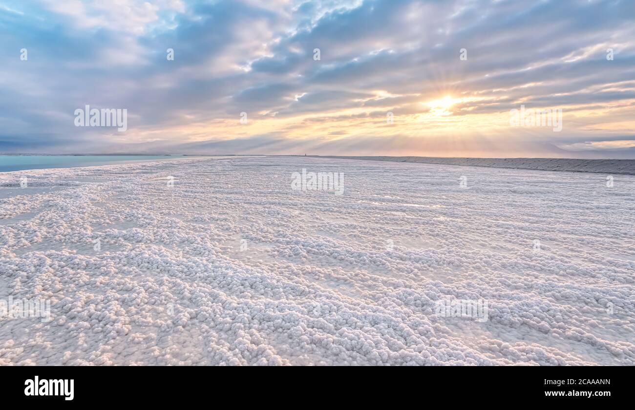 Crystalline white salt beach lit by morning sun, small puddles with ...