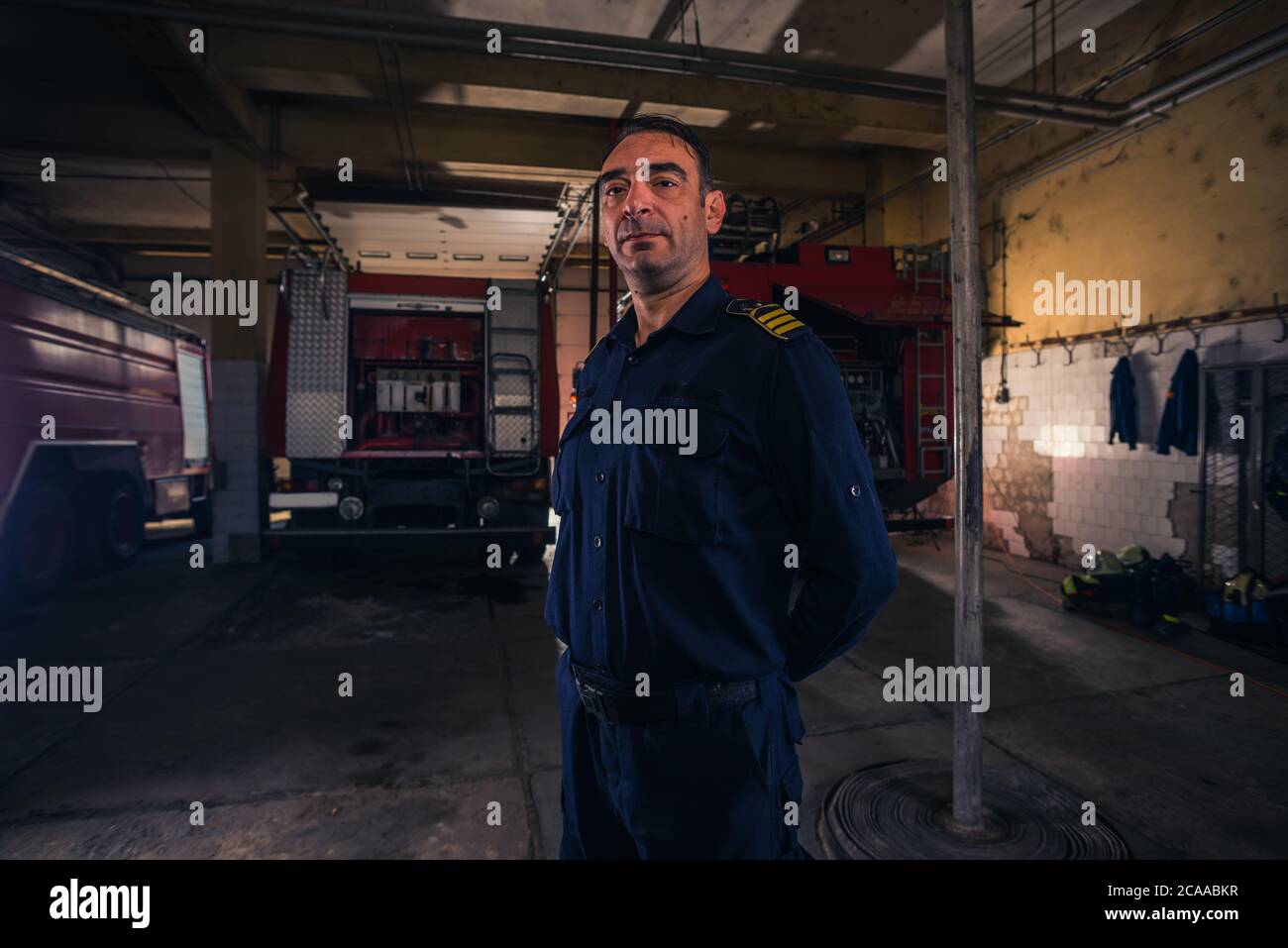 Portrait of fireman standing inside the fire department Stock Photo - Alamy
