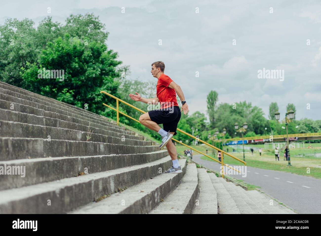 Fit male athlete performing stairs workout, running up climbing stairs ...