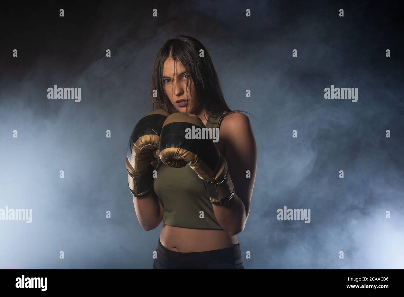 Closeup portrait of a female boxer posing with boxing gloves and ...