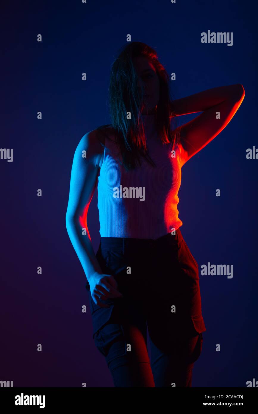 Female model posing in studio with red and blue colors at high contrast ...